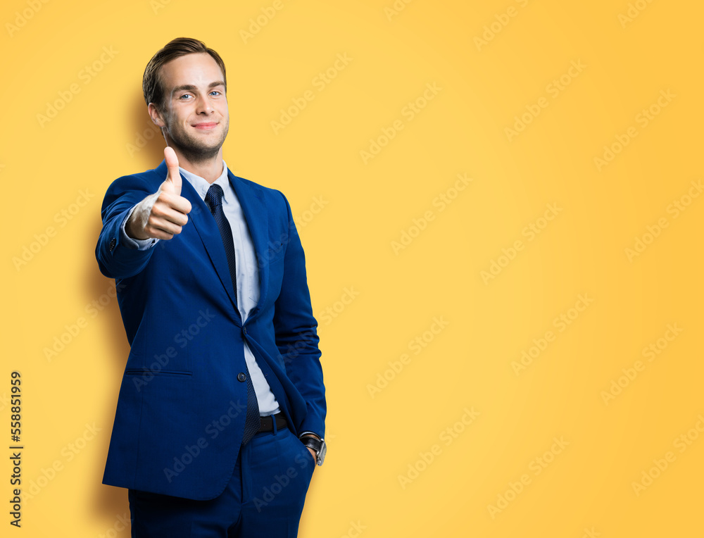 Smiling businessman showing thumb up like sign gesture, in blue suit ... Smiling businessman showing thumb up like sign gesture, in blue suit ...