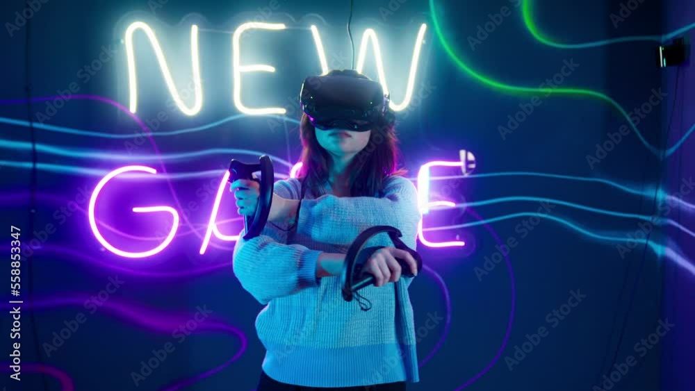 Cyber gamer in VR glasses plays virtual reality game in neon futuristic ...
