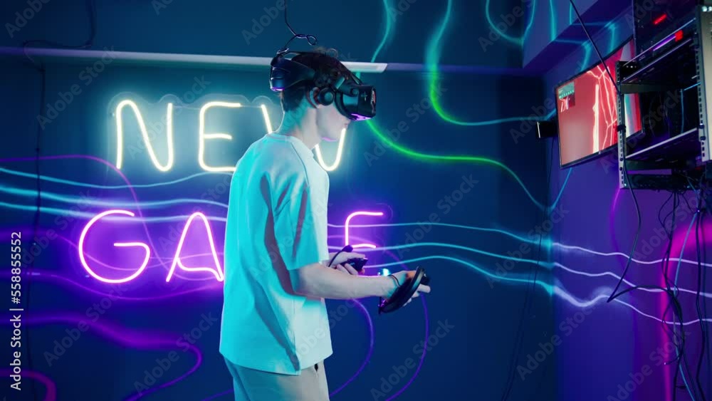 Cyber gamer in VR glasses plays virtual reality game in neon futuristic ...