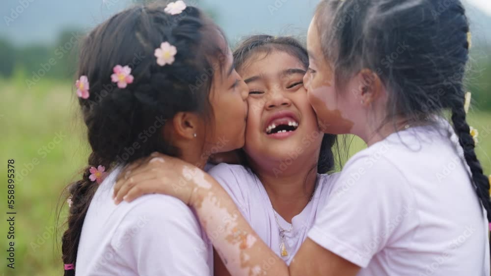 Three little cute child asia sisters kiss cheek cuddle hug look at ...