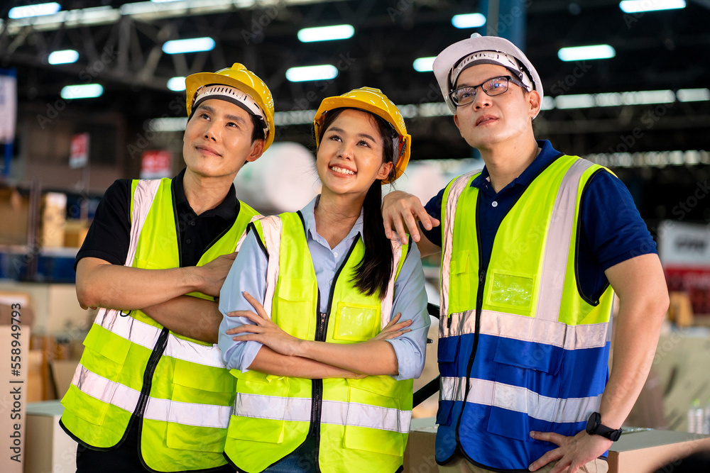 Collaborative team wearing reflective jackets and safety helmets ...