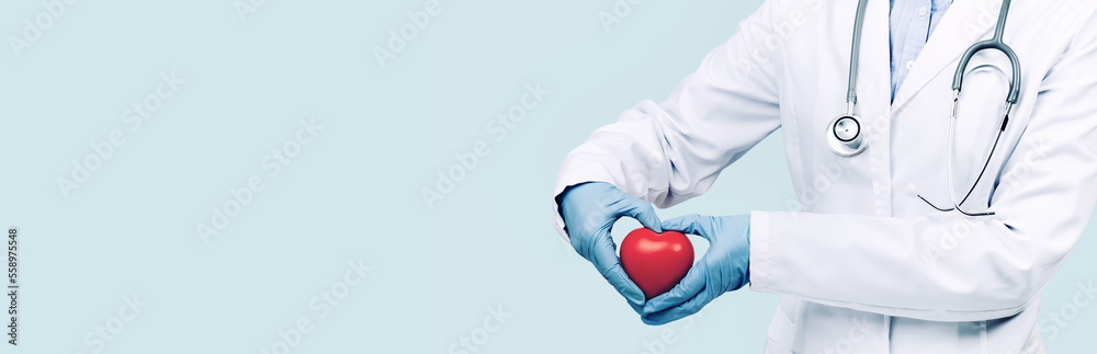 Female doctor in white uniform forms a heart shape with her hands ...