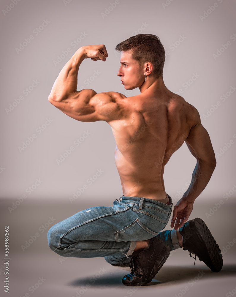 Young bodybuilder in kneeling pose in studio shot Stock Photo | Adobe Stock