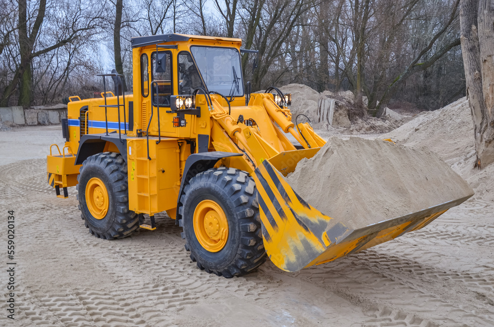 Wheel loader working in a gravel pit. Mining machines moving clay ...