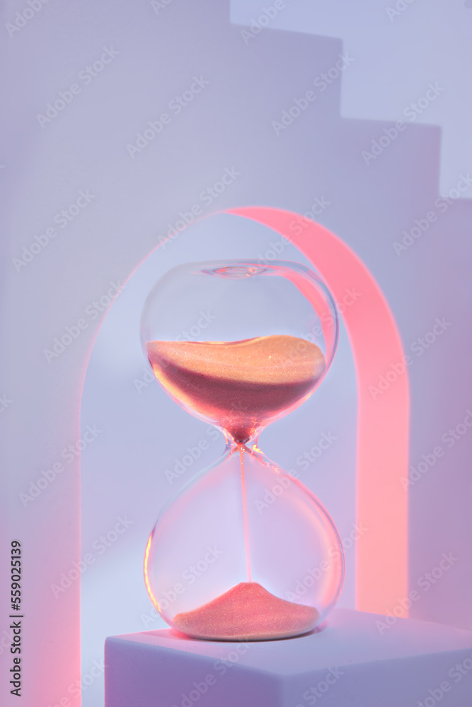 Hourglass on podium. Surreal arches in pink and purple neon lights ...