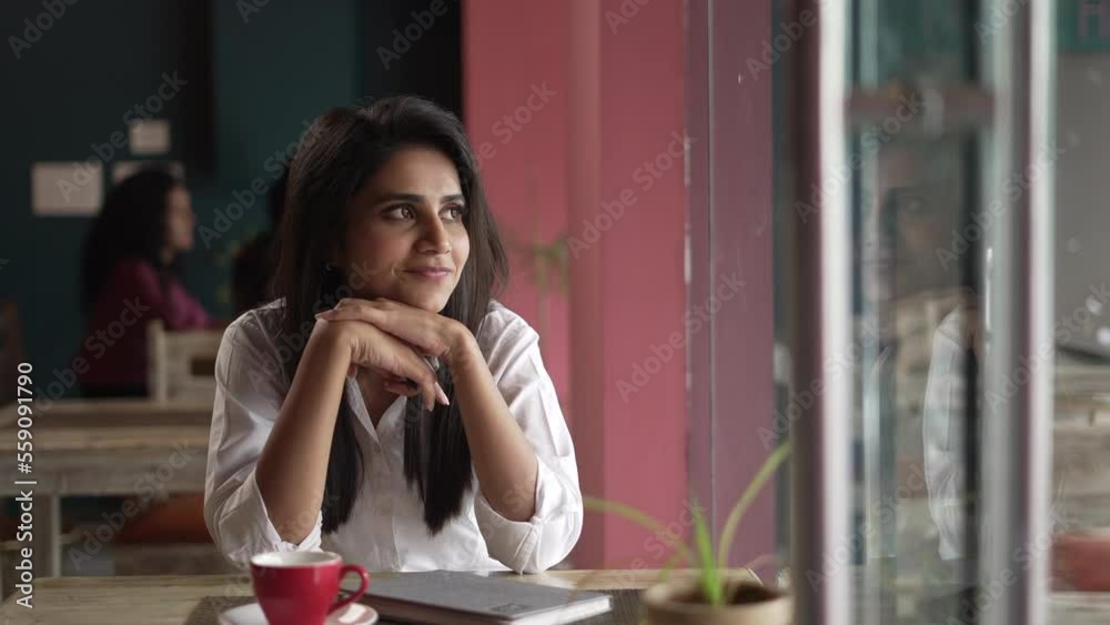 Attractive Indian female recreating in favorite cafe organizing ...