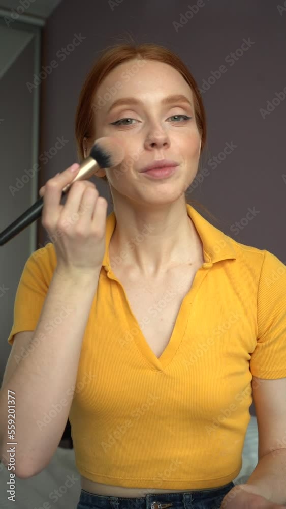 Vertical POV of millennial female influencer filming daily makeup routine tutorial. Influencer ...