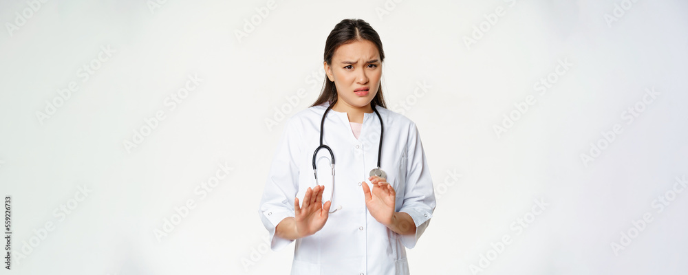 Disgusted asian female doctor rejecting, saying no, looking with ...