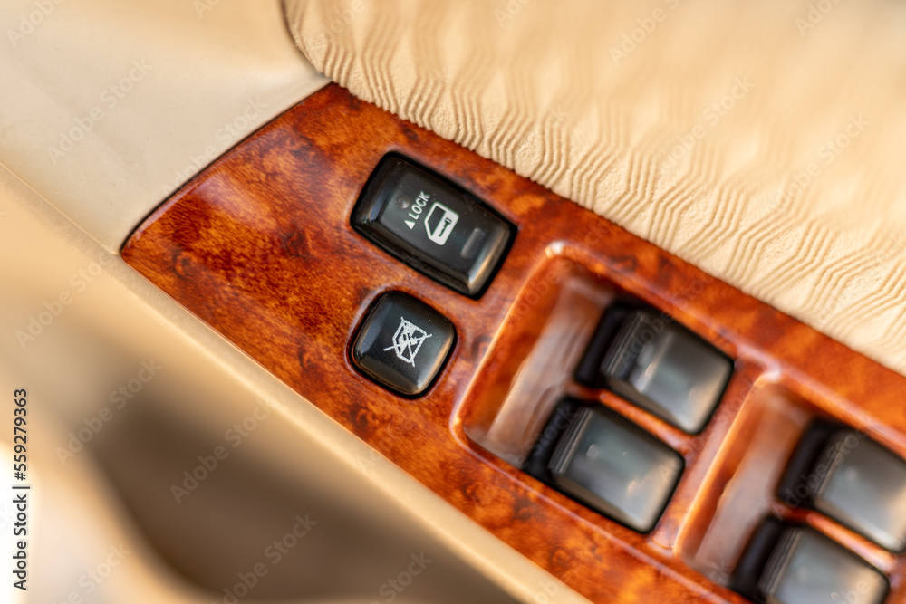 Car's window lock and unlock button on the arm of a driver side door ...