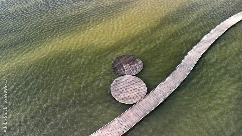 floating walkway made of wooden planks. narrow curved paths on stilts ...