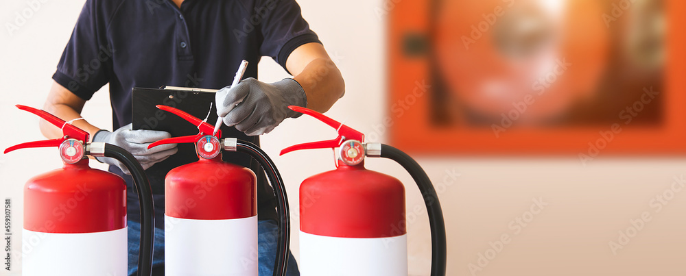 Close up fire extinguisher and firefighter checking pressure gauge ...