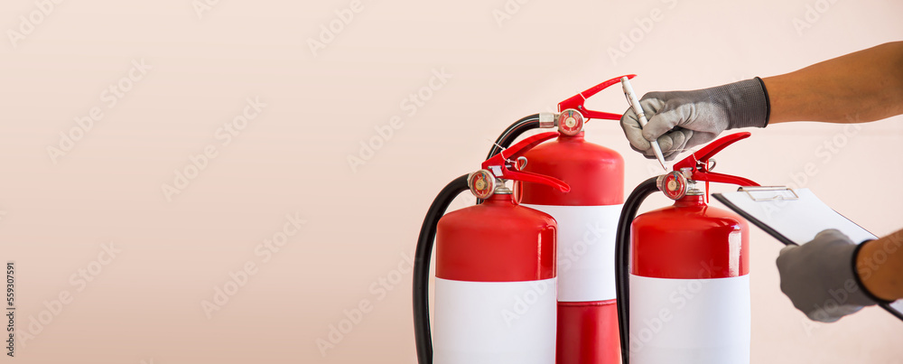 Close up fire extinguisher and firefighter checking pressure gauge ...