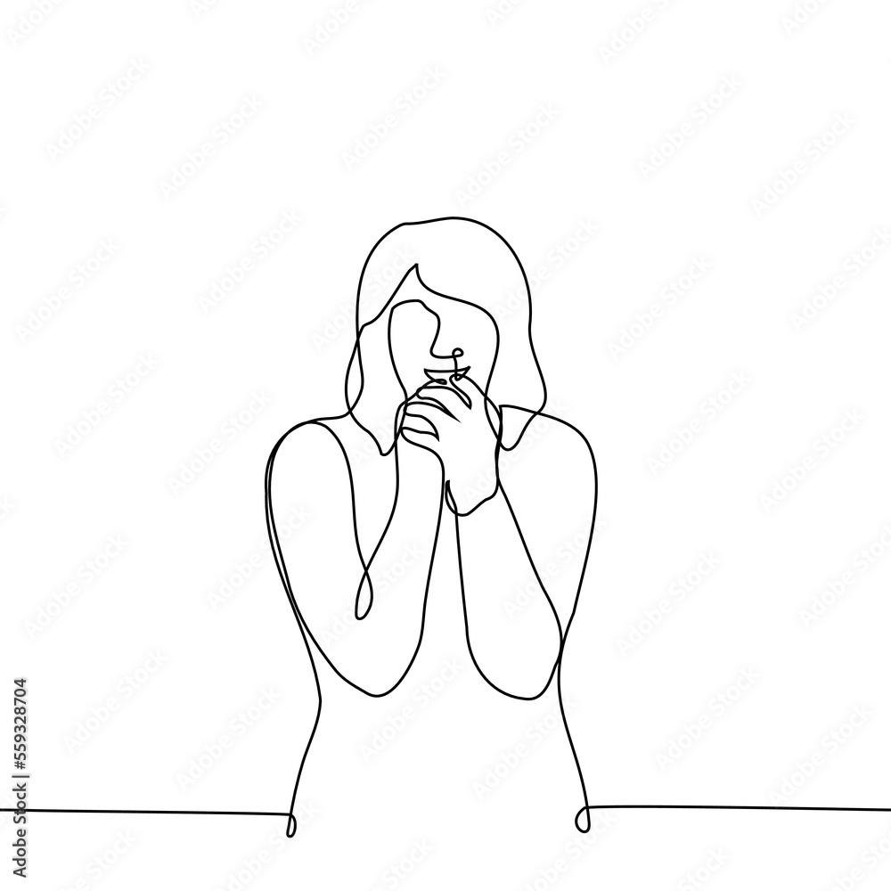 woman stands excited, raising and folding her hands near her face, she ...