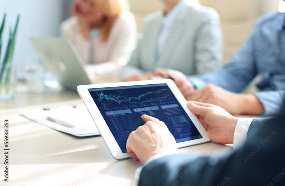 Business person analyzing financial statistics displayed on the tablet ... Business person analyzing financial statistics displayed on the tablet ...