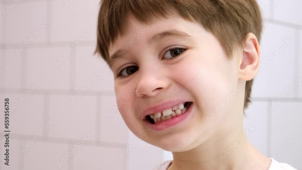 Cute smiling child looking at camera. Boy shows a smile with the milk ...