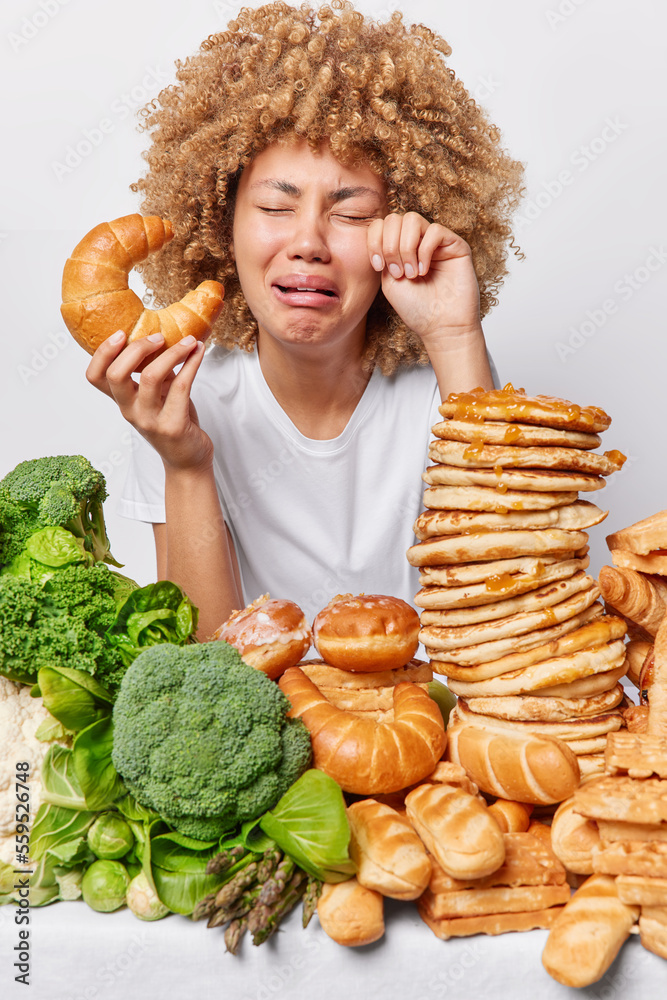 Unhealthy diet and weight loss concept. Doleful curly haired woman ...