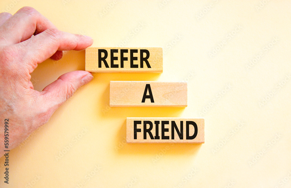 Refer a friend symbol. Concept words Refer a friend on wooden blocks on ...