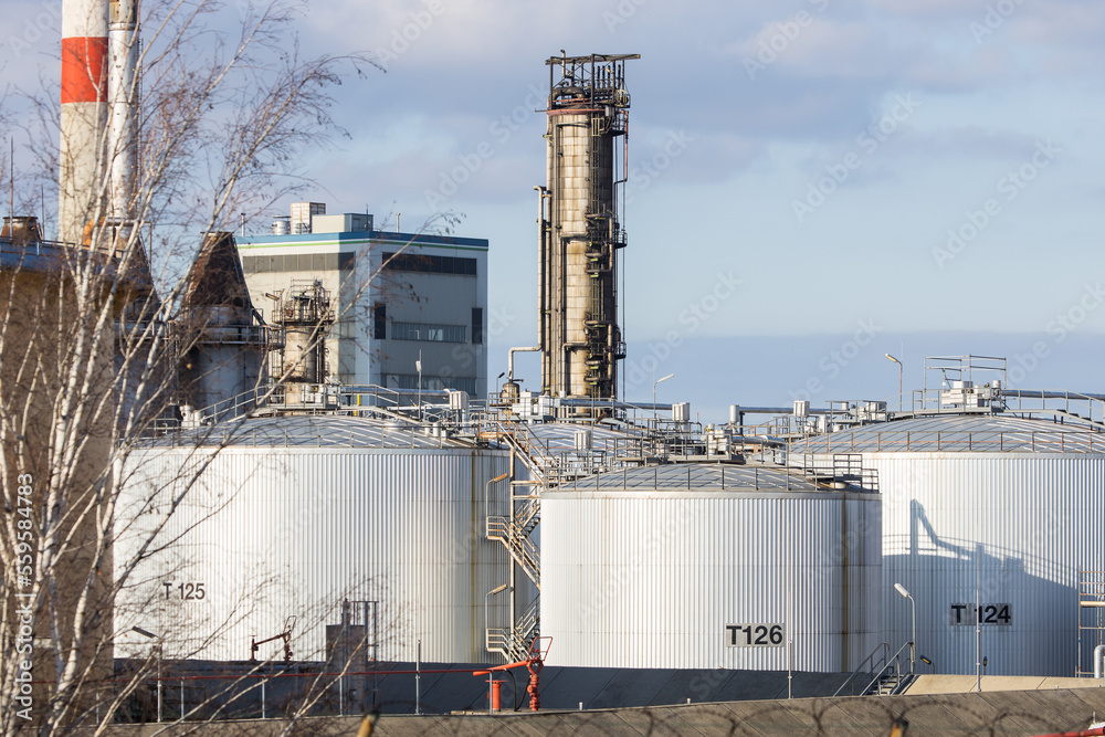 Refinery complex with fuel storage tanks, smokestacks and pipes with ...