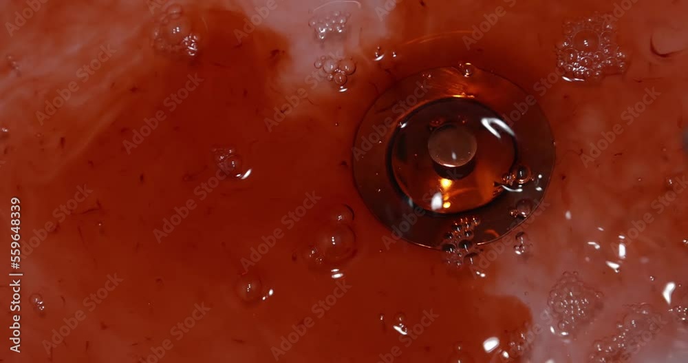 A person letting water full of blood going to the sink. Concept: horror ...