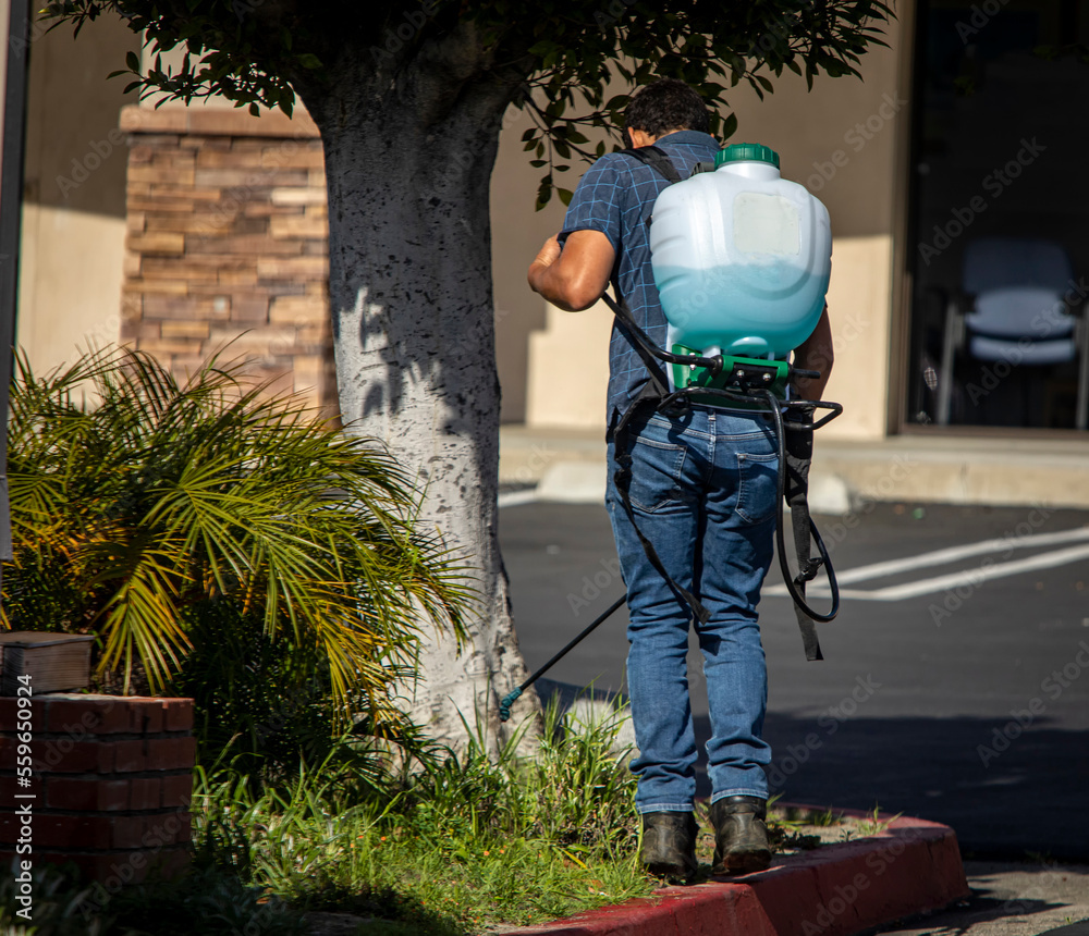 Man spraying insecticide or fertalizer at a shopping center Stock Photo ...