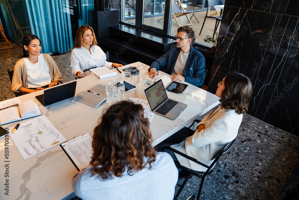 Different age colleagues discussing their project during offline ...