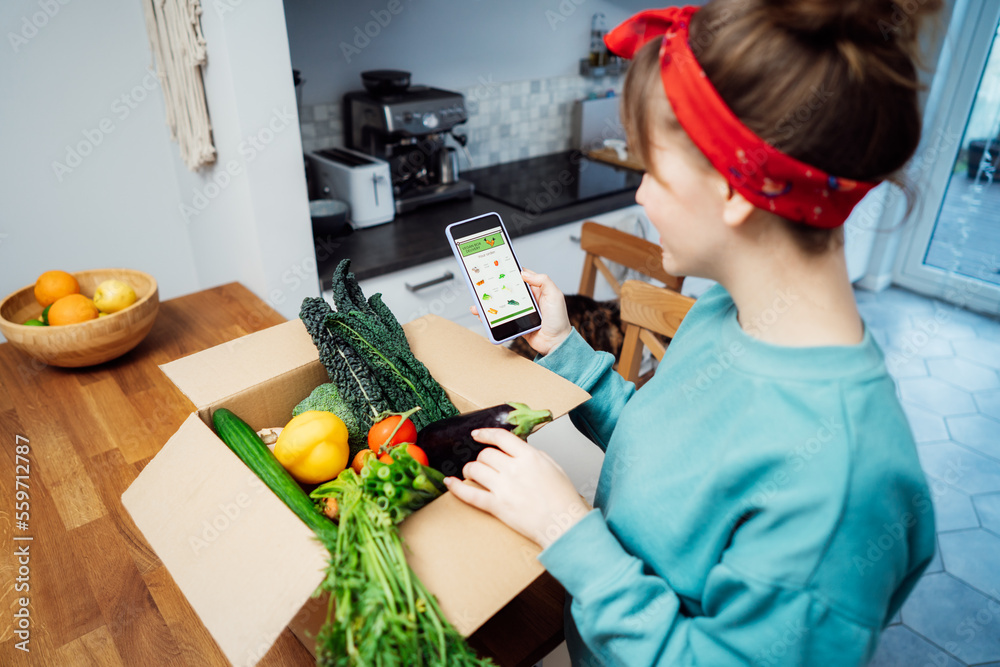 Online home food delivery. Woman checking her online order list on her ...