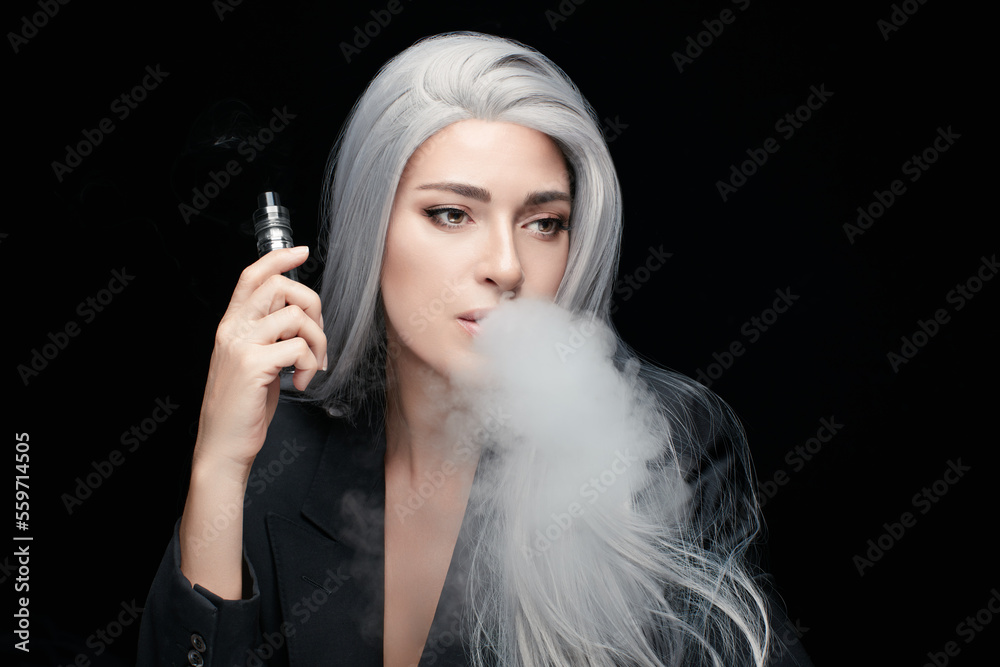 Sensual gray haired woman using electronic cigarette. Beauty model ...