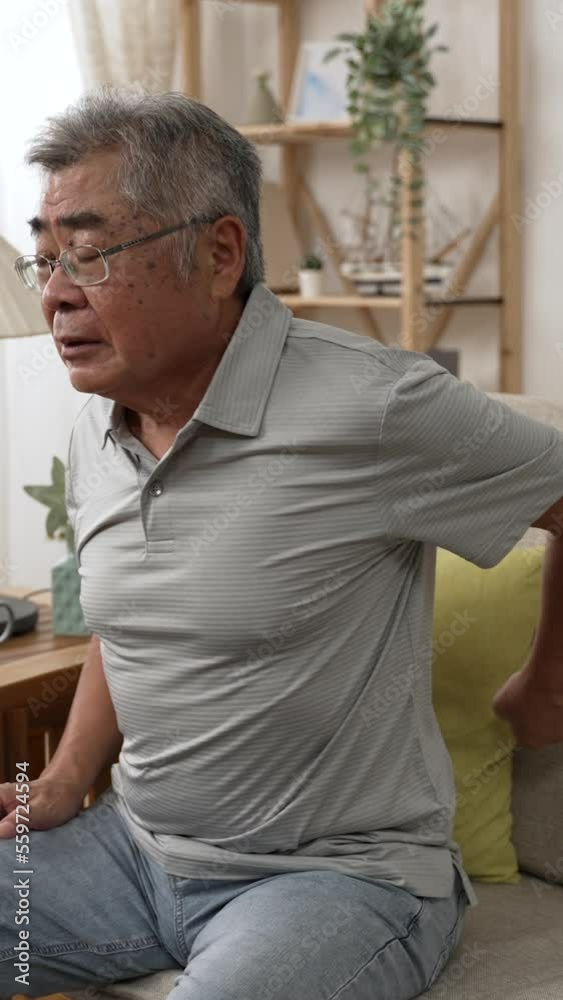 Vertical Screen: Sad senior asian man with white hair sitting on couch ...