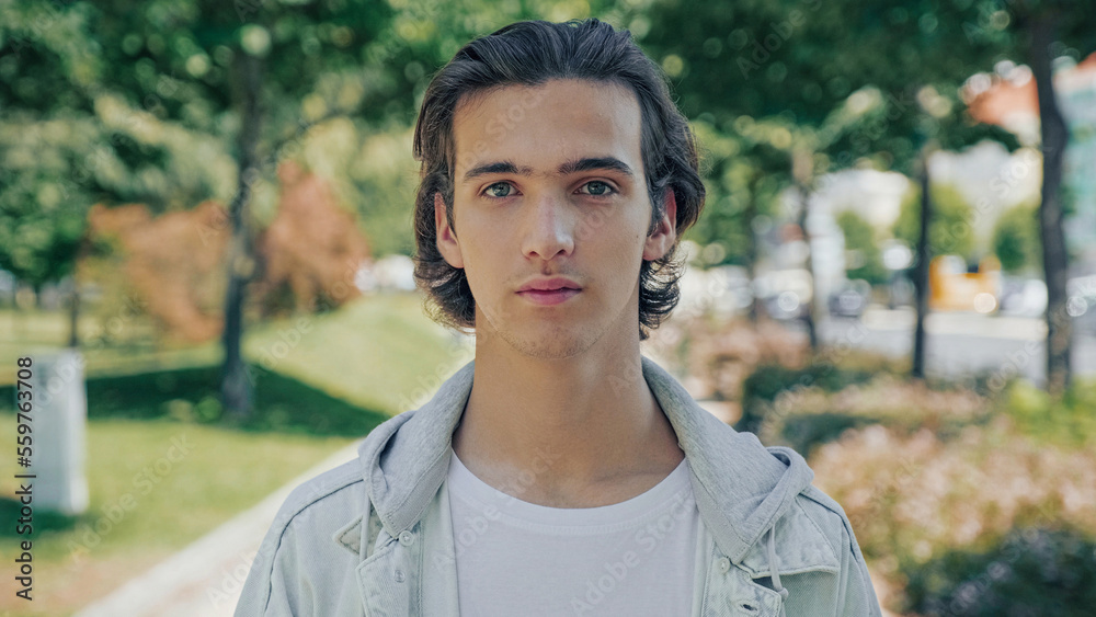 Closeup portrait of handsome confident young man at the park in summer ...