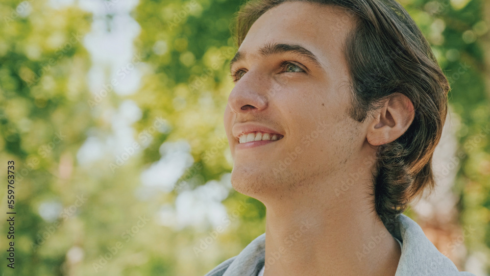 Closeup portrait of happy handsome young man at the park in summer ...