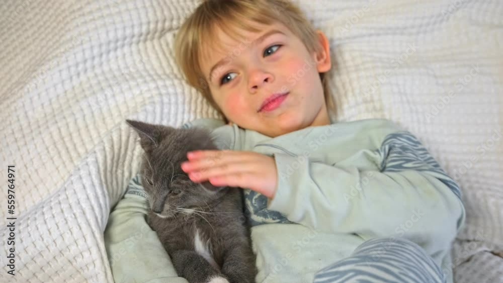 Portrait of Funny Little Boy Cuddling Gray Kitten Lying in a Bed. Pet ...