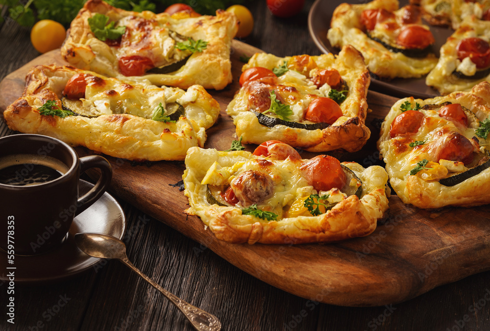 Crispy puff pastry mini tarts with zucchini, tomatoes and cheese. Stock ...