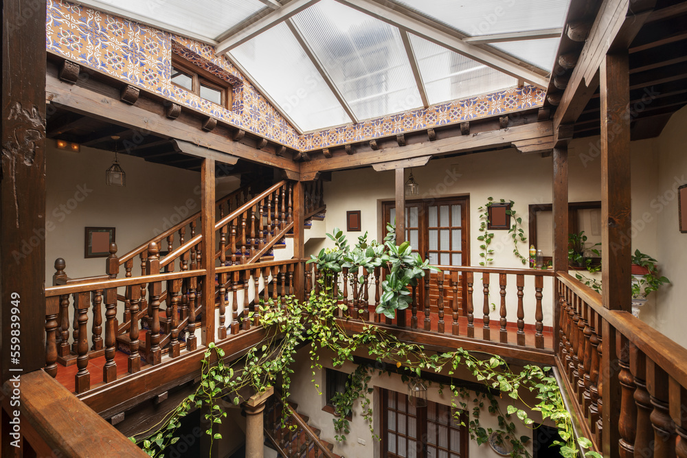 Atrium of an old house with wooden railings on the stairs and on the ...