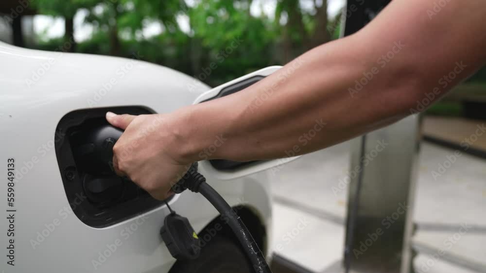 Progressive man install power cable plug to his electric vehicle, EV ...