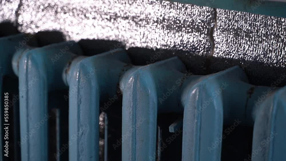 Old cast-iron heating radiator of blue color in the room close-up ...
