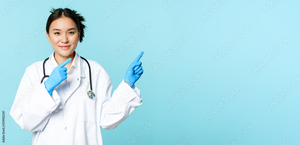 Smiling asian healthcare worker, wearing sterile gloves and uniform ...