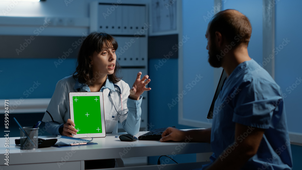 Medic holding tablet computer pointing at green screen chroma key ...