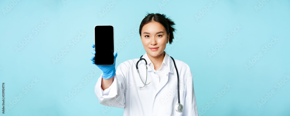 Web medical doctor concept. Smiling asian physician showing mobile ...