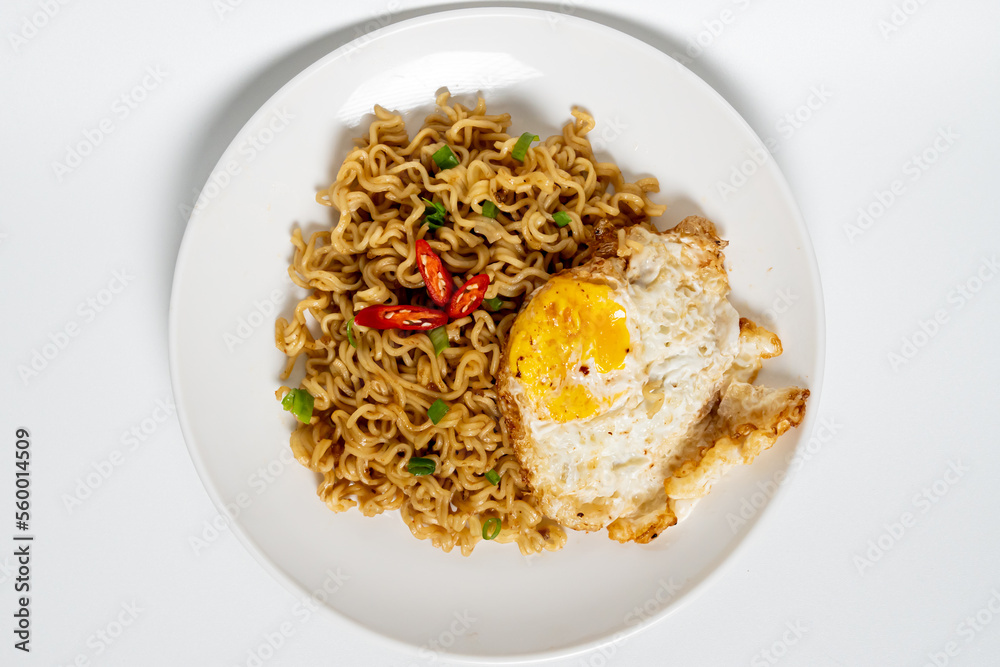 Top view of Indomie fried noodles (mi goreng) with sunny side up egg ...