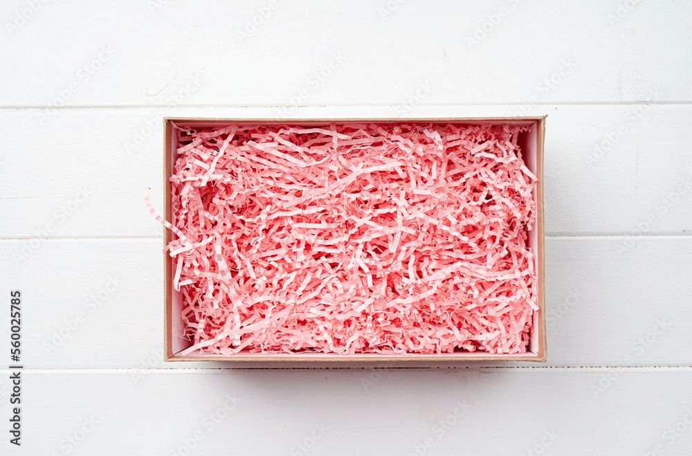Shredded pink paper packing material texture in a craft box, mockup ...