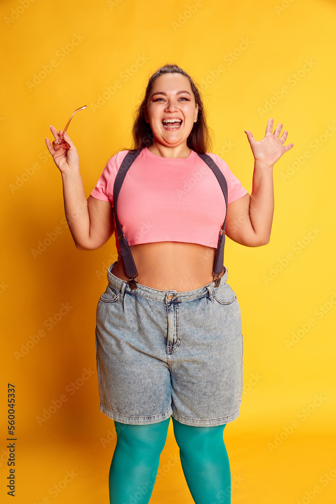 Super happy. Portrait of young overweight woman in casual bright ...
