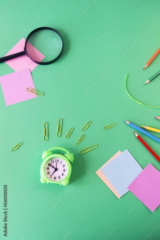 Stationery, alarm clock, books on a background of pastel colors of ...