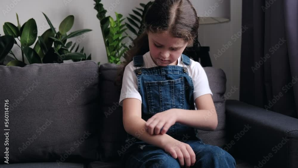 Close up of unhealthy sad little girl child sitting alone on sofa at ...