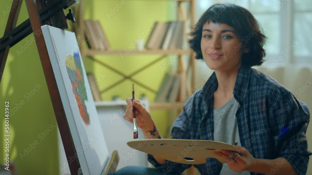 An artist woman with very magnetic eyes is staring into the camera as ...