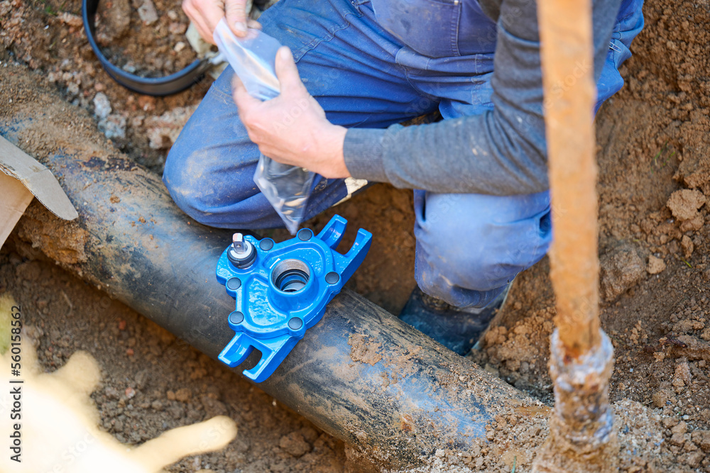 Construction worker, repairing a broken water pipe Construction site ...