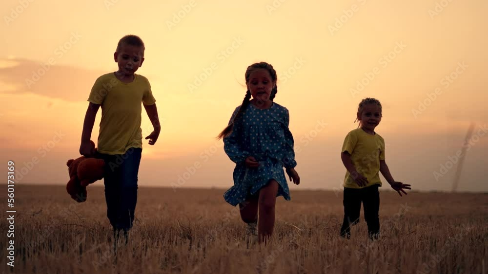 Happy family in nature. Sunset over a wheat field. Children run around ...