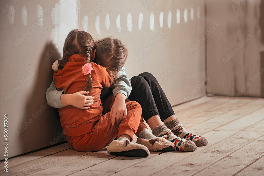 two little sister girls hugged and crying in the attic of the house ...
