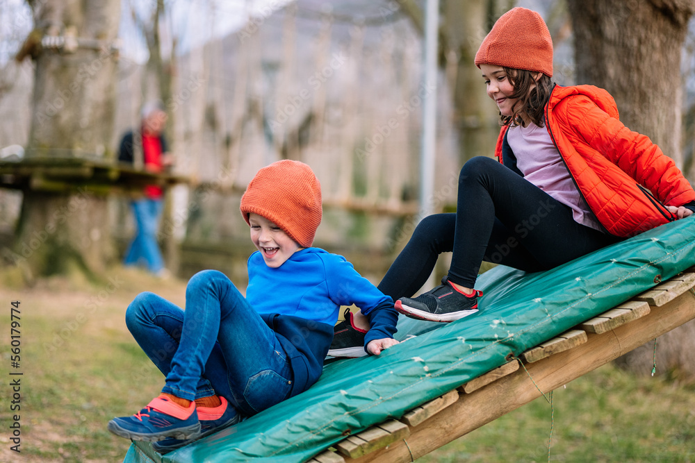 Happy children sliding on playground Stock Photo | Adobe Stock