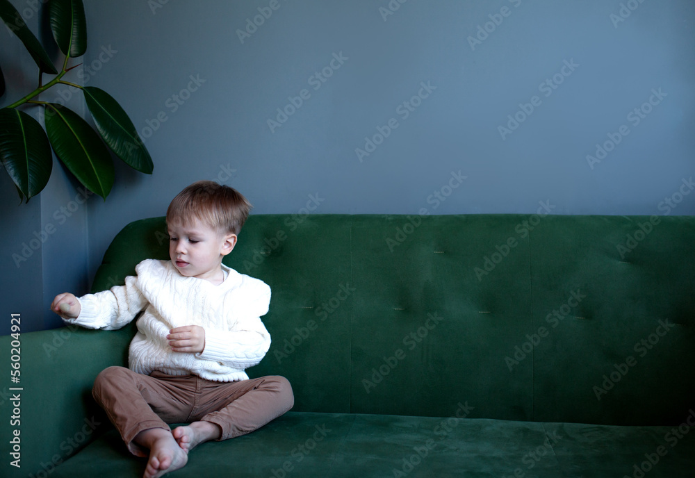 Foto de The two years old boy sit in the gteen sofa in the room . Cute ...