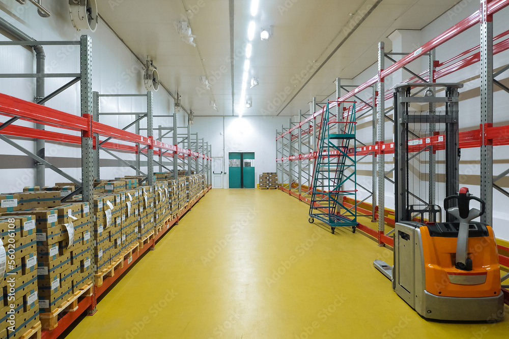 Warehouse of a food production factory. Compact electric forklift truck ...